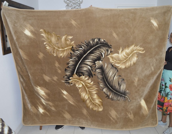 Manta da marca cortex, nas cores beges e marrom, decora